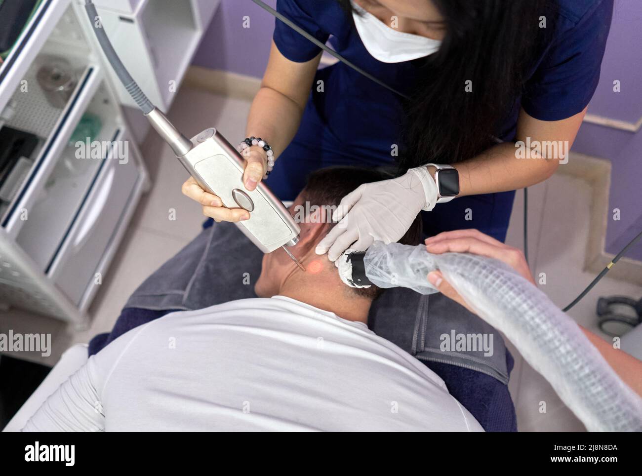 Back of a patient receiving a beauty treatment on the neck using a ...