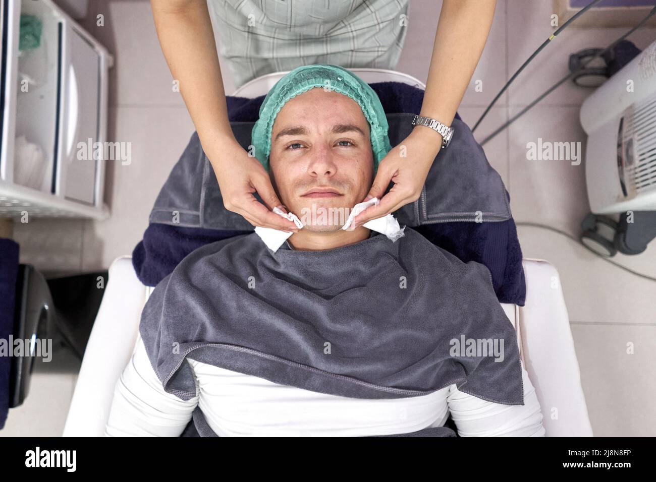 Top view of a man lying down on a stretcher ready for a facial beauty ...