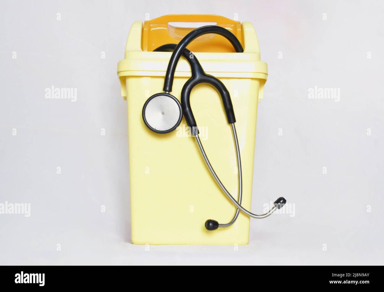 Black Stethoscope in Small Yellow Plastic Trash Can. Shows Quit the ...