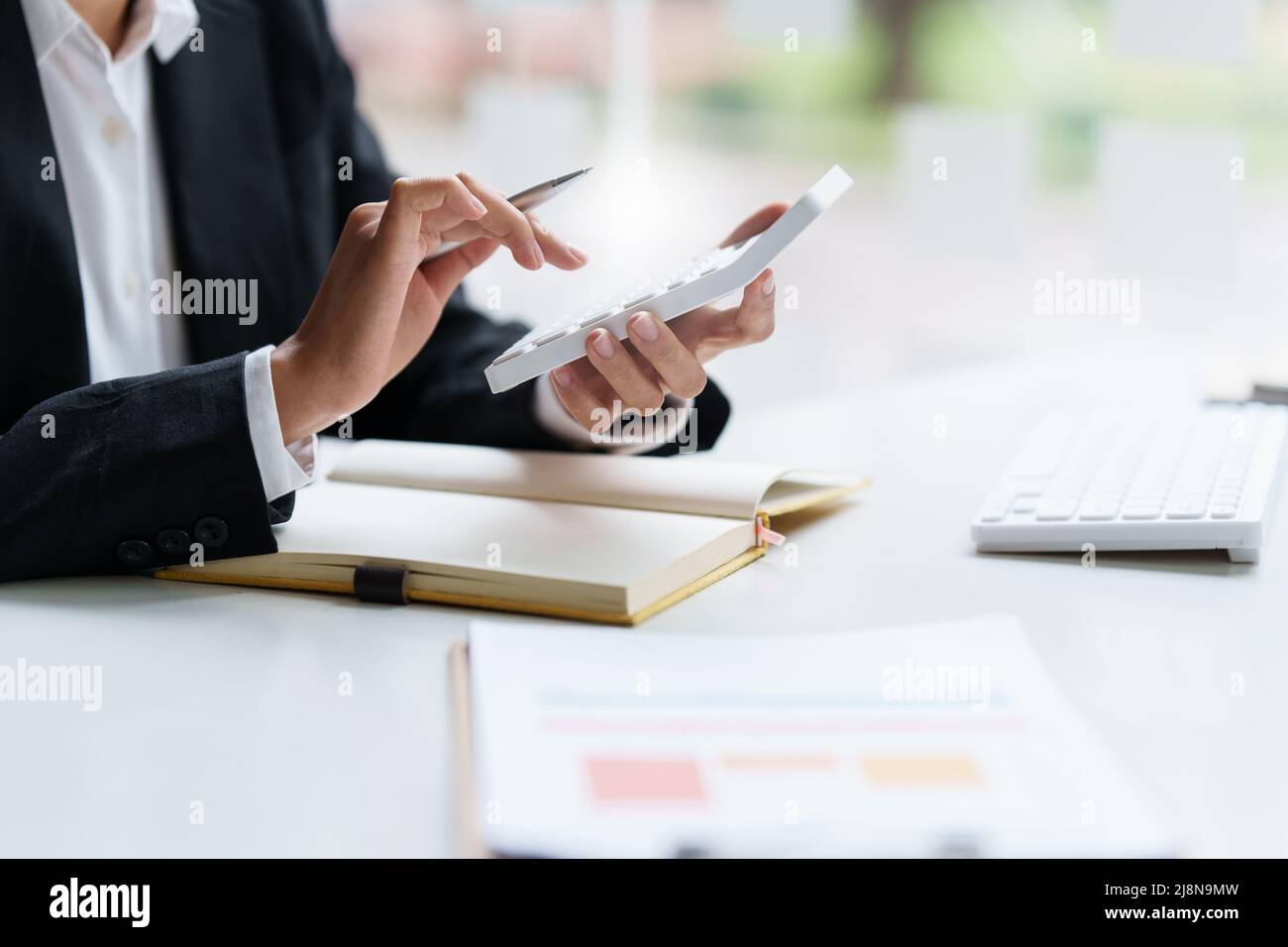 Asian Business Woman or Accountant do math and analyze with calculator ...