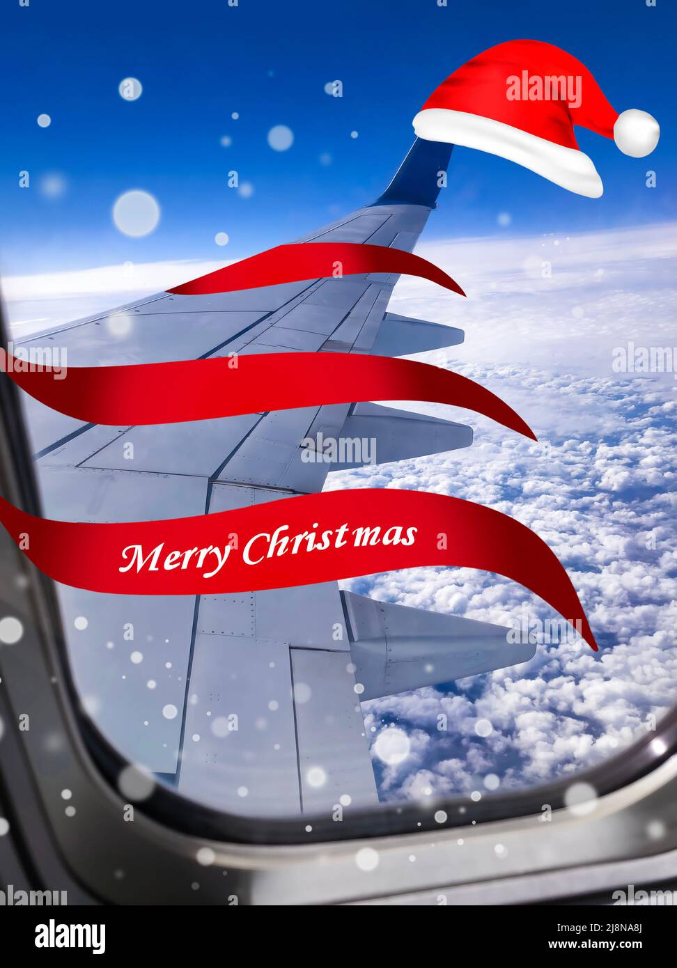 Airplane with red Santa Christmas hat over clouds and blue sky ...