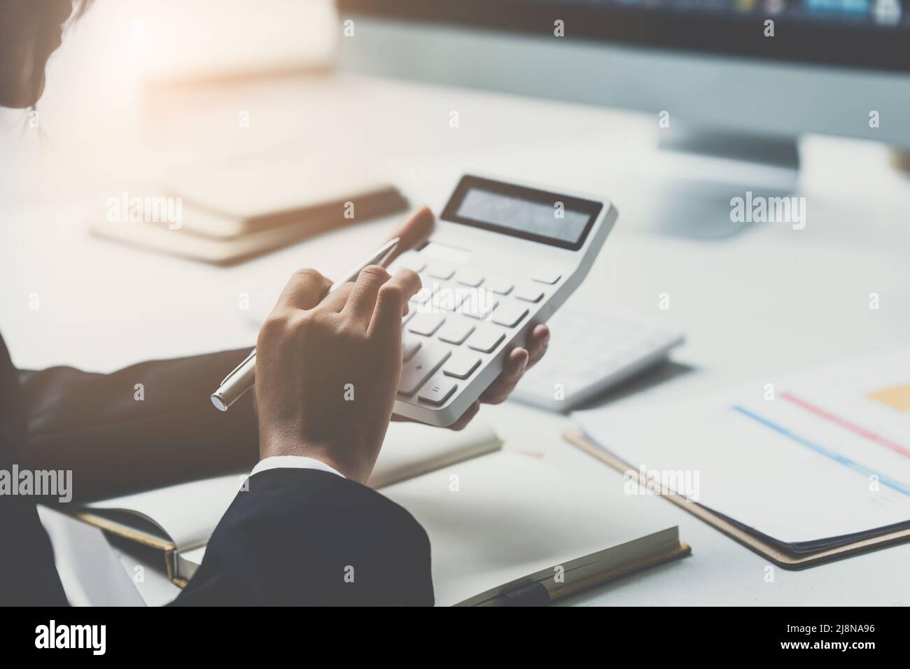 Asian Business Woman or Accountant do math and analyze with calculator ...