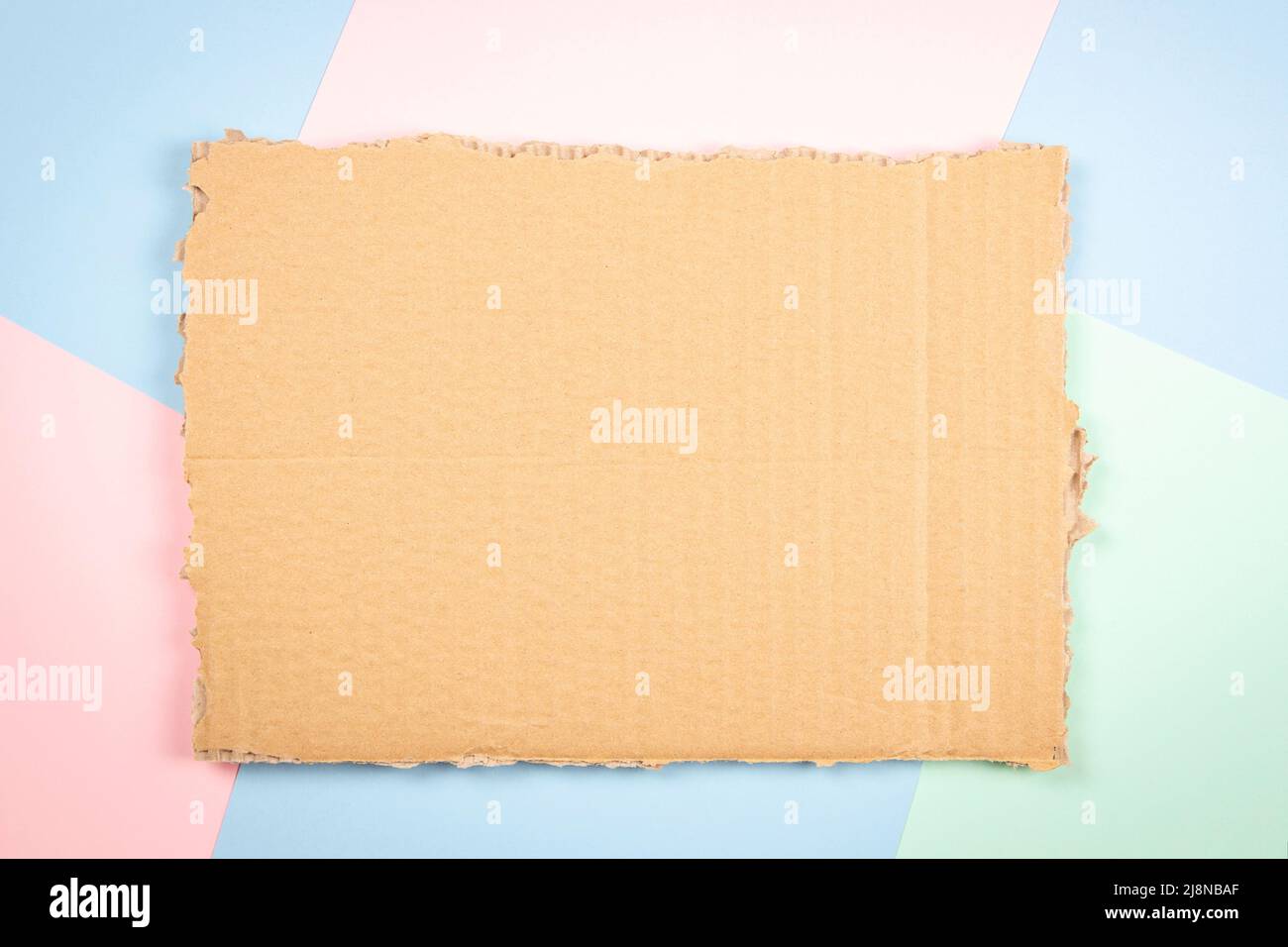 Piece of brown corrugated cardboard on colorful background. Ripped ...