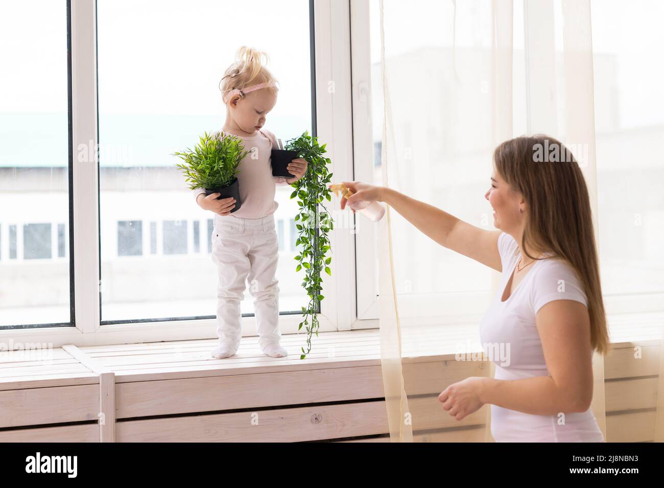 Happy child girl with cochlear implant having fun with her mother ...