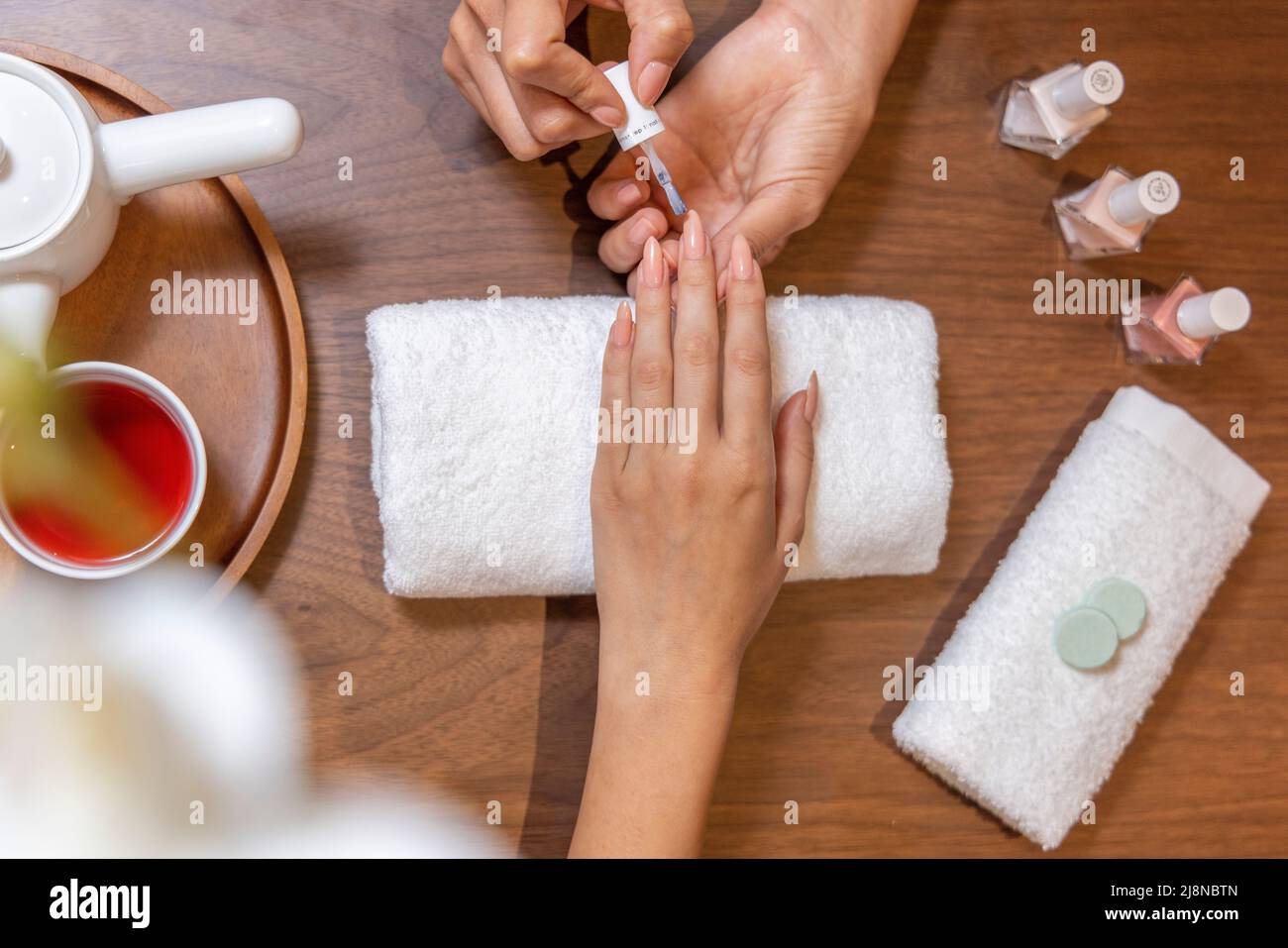 Nail artist polishing nails for client Stock Photo - Alamy
