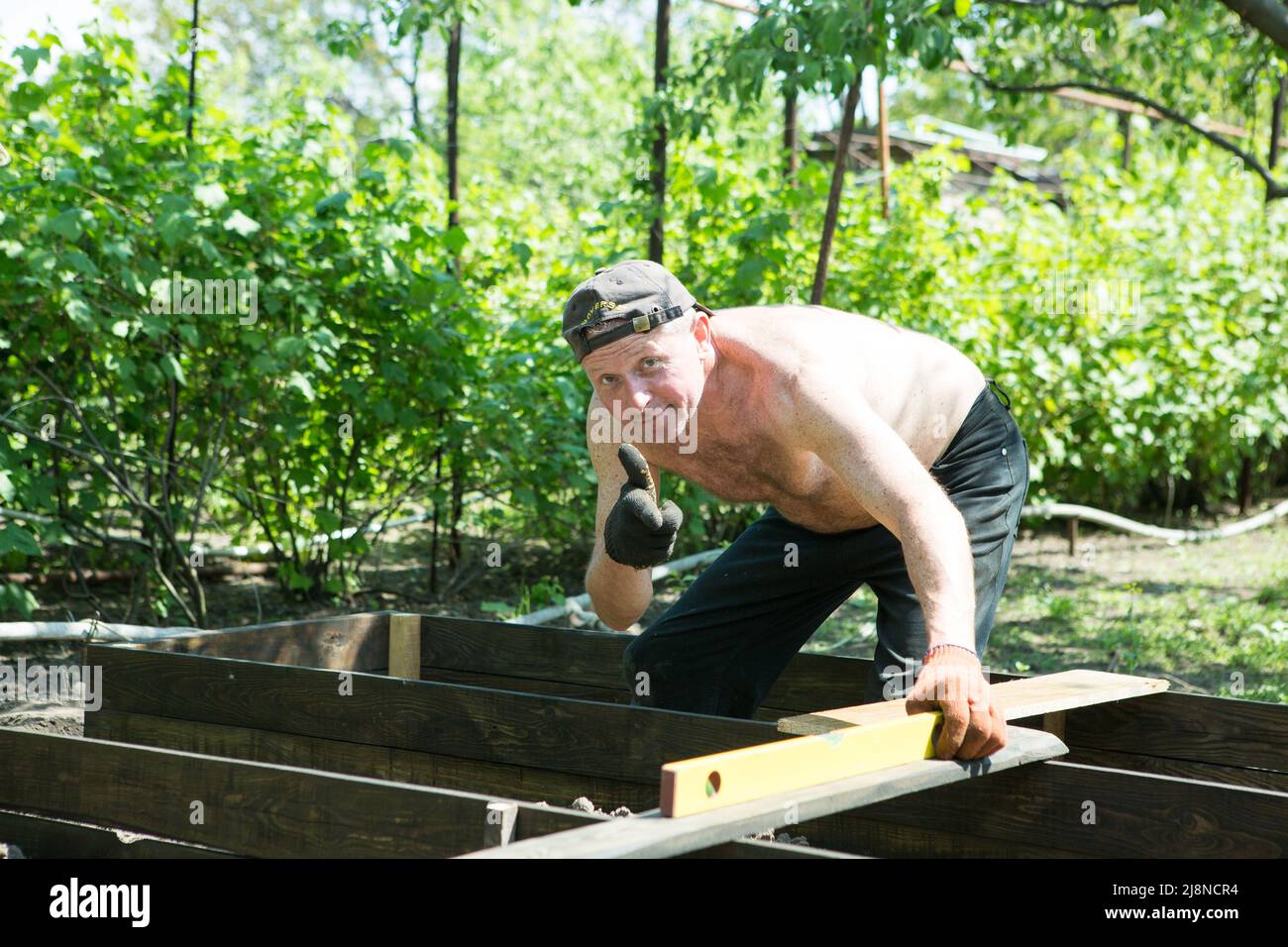 A man of mature years makes high beds on a personal plot. The master ...