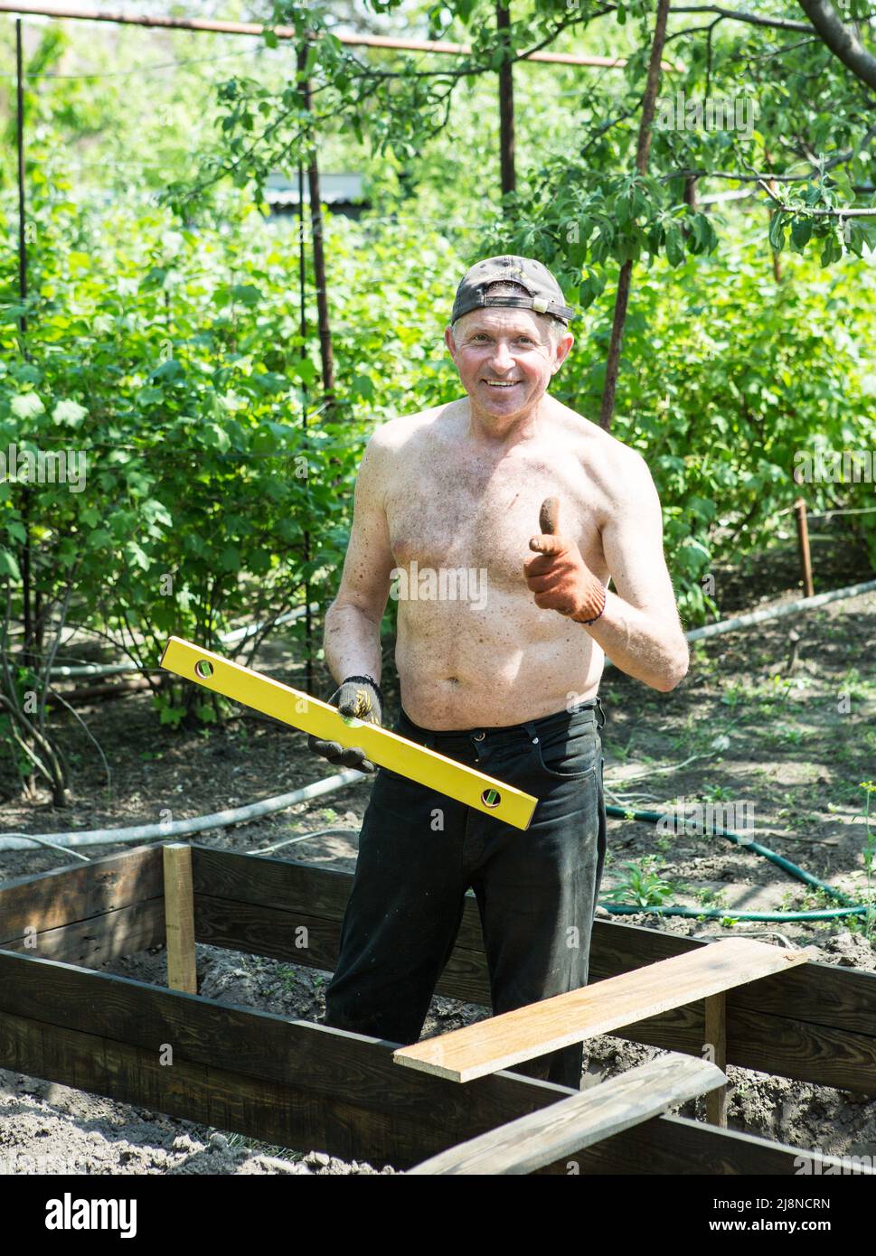 A man of mature years makes high beds on a personal plot. The master ...