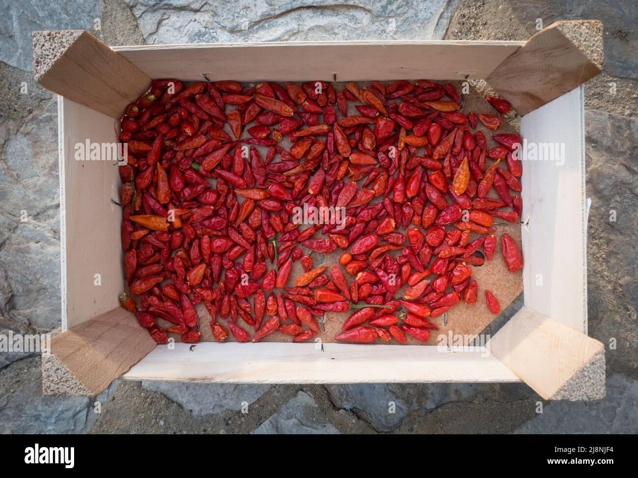 Wooden box with dried hot chili peppers Stock Photo - Alamy