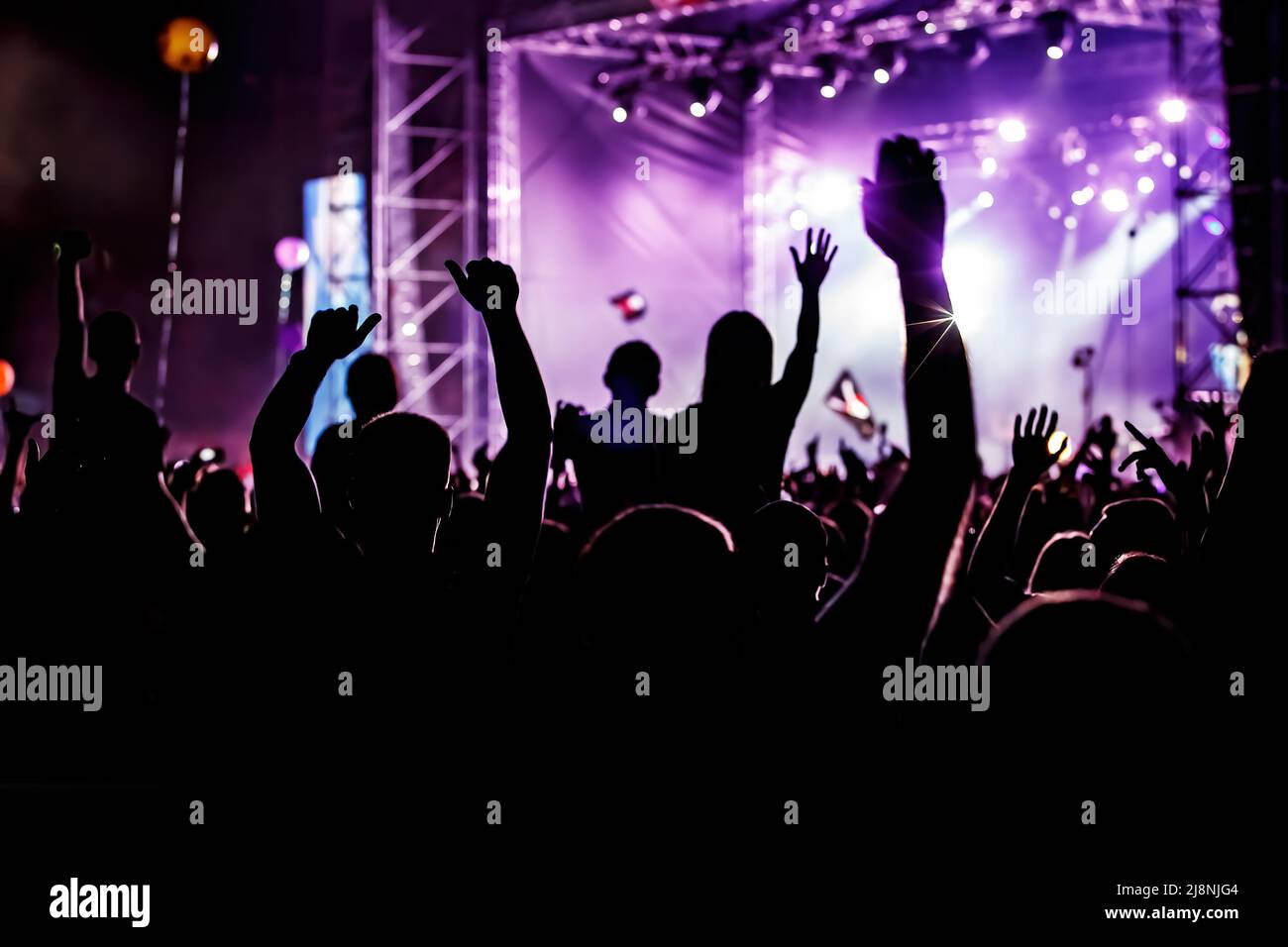 Men and women with raised hands at a concert event Stock Photo - Alamy
