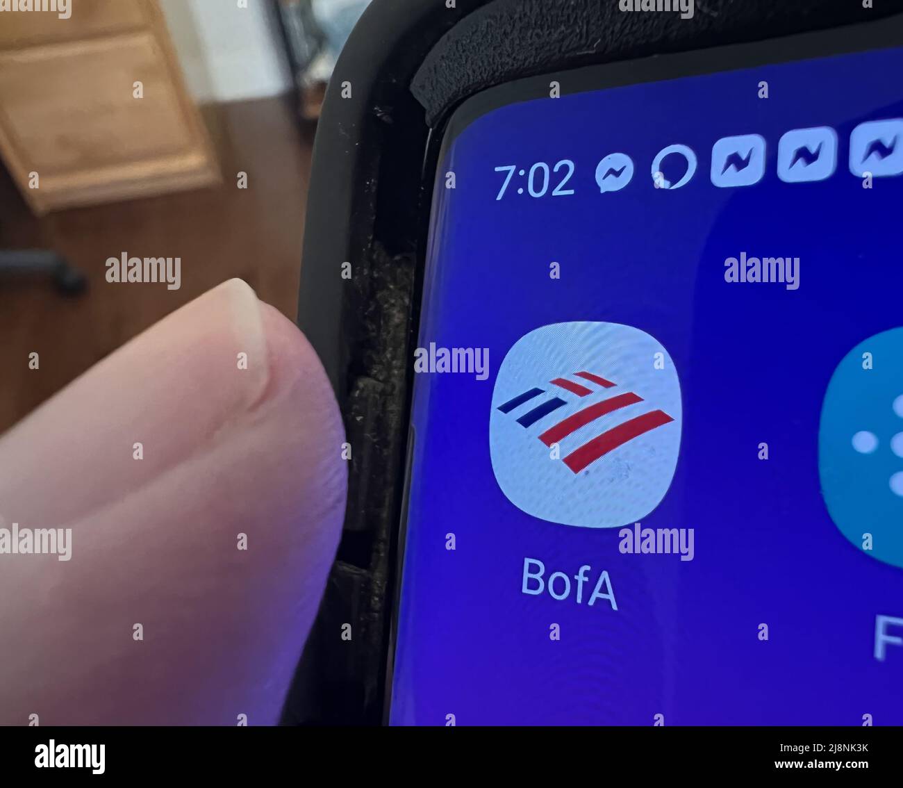Person's hand holding a cellphone with Bank of America (aka BofA) app ...