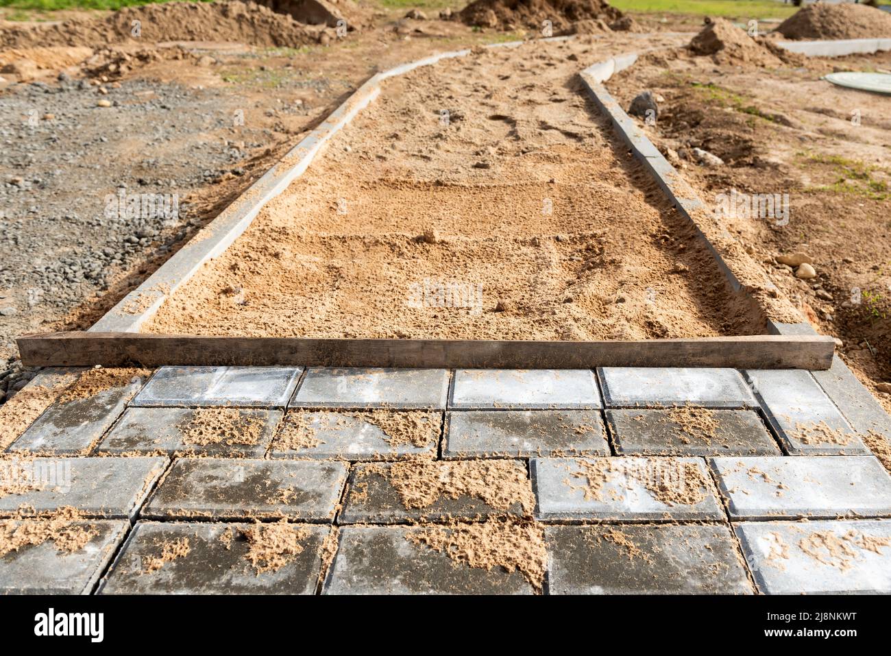Laying the path with paving bricks. Street improvement. Construction of ...
