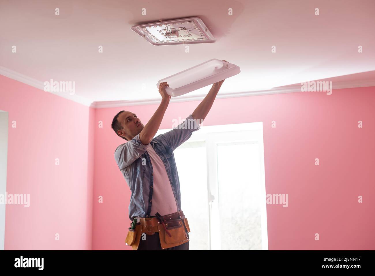 electrician installing a led light on the ceiling Stock Photo - Alamy