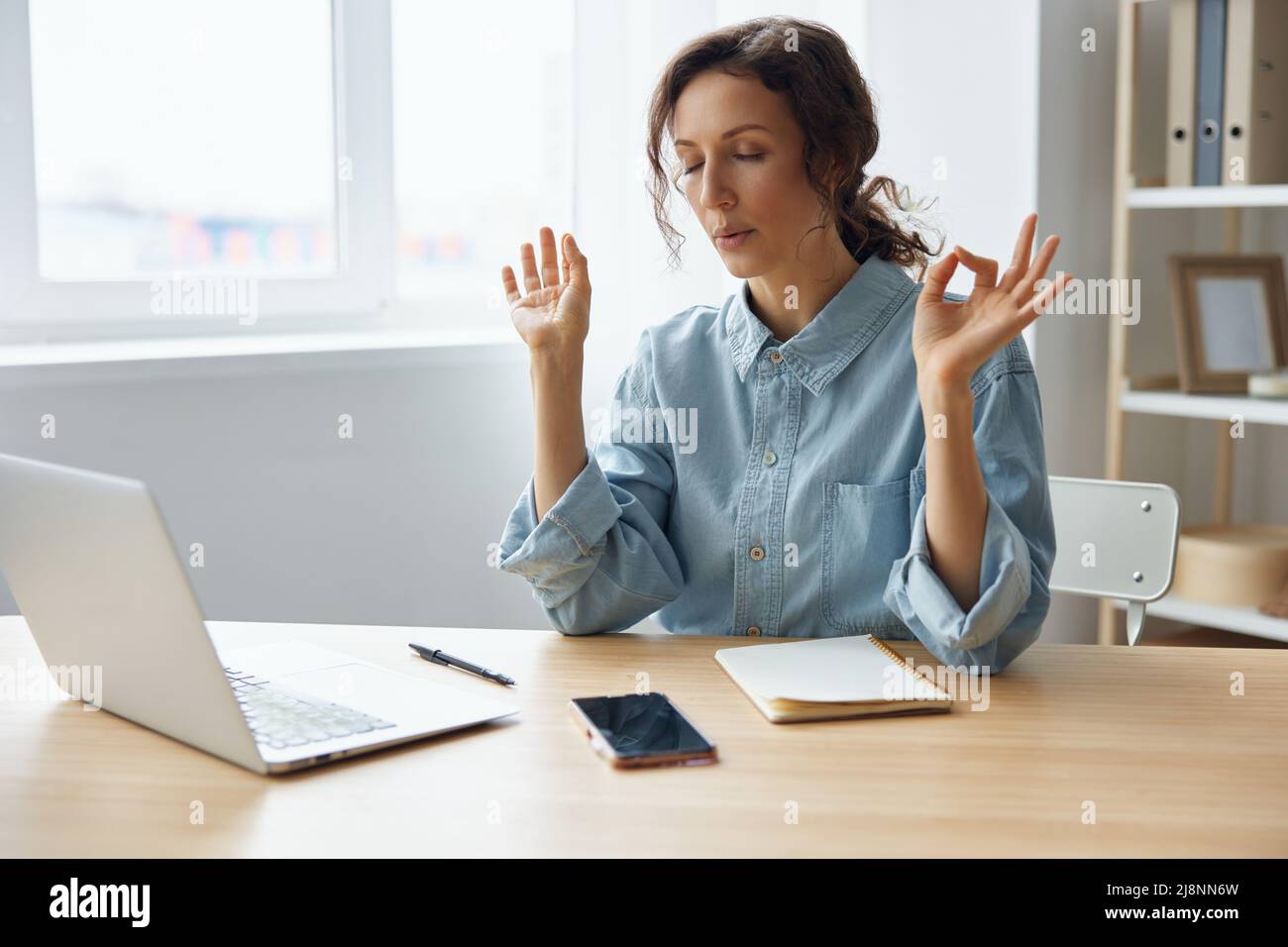 Serious irritated anxious angry curly-haired businesswoman is trying to ...