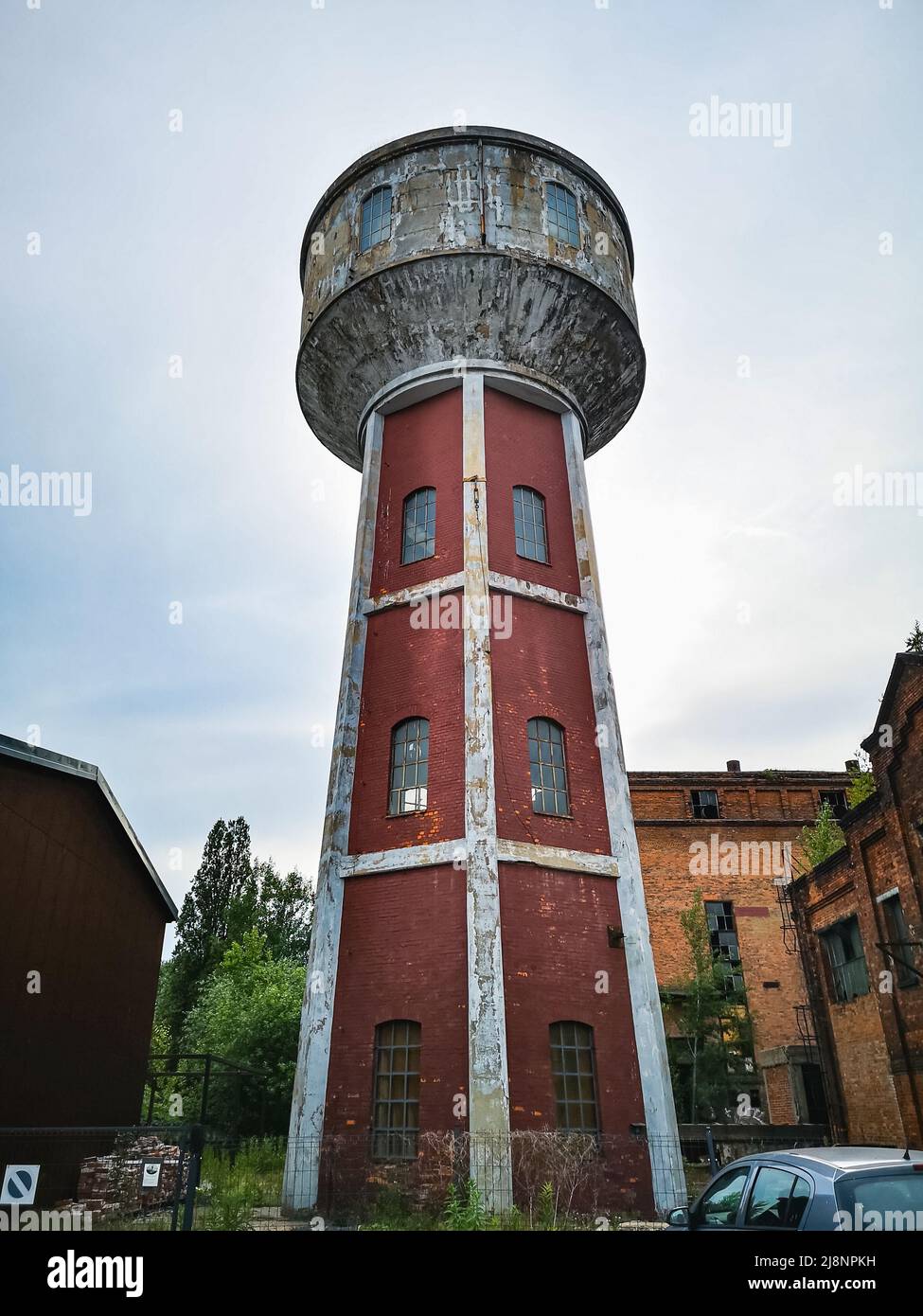 High red brick tower as part of old factory complex Stock Photo - Alamy