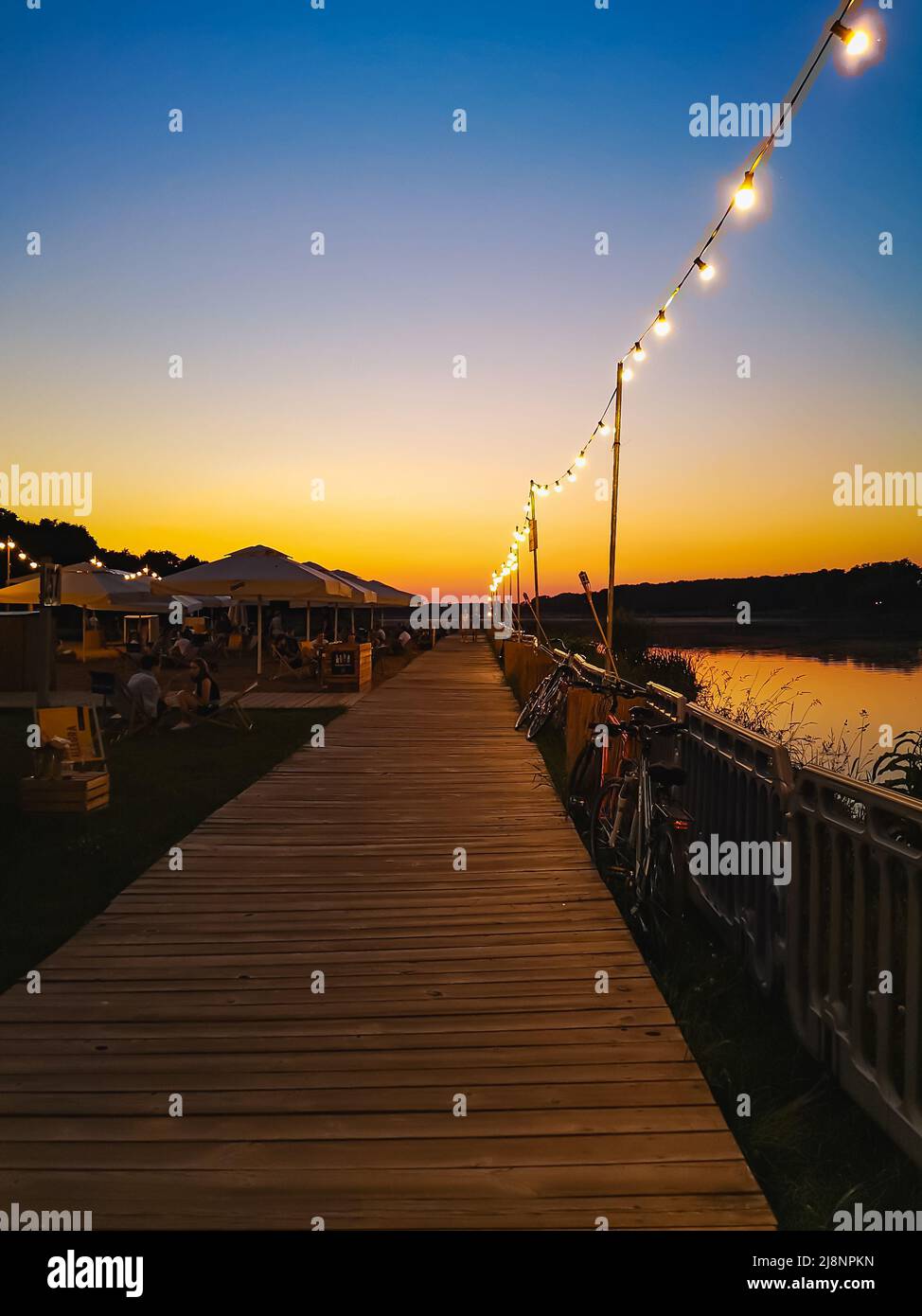 Beautiful sunset over small beach bar next to Odra river full of small ...