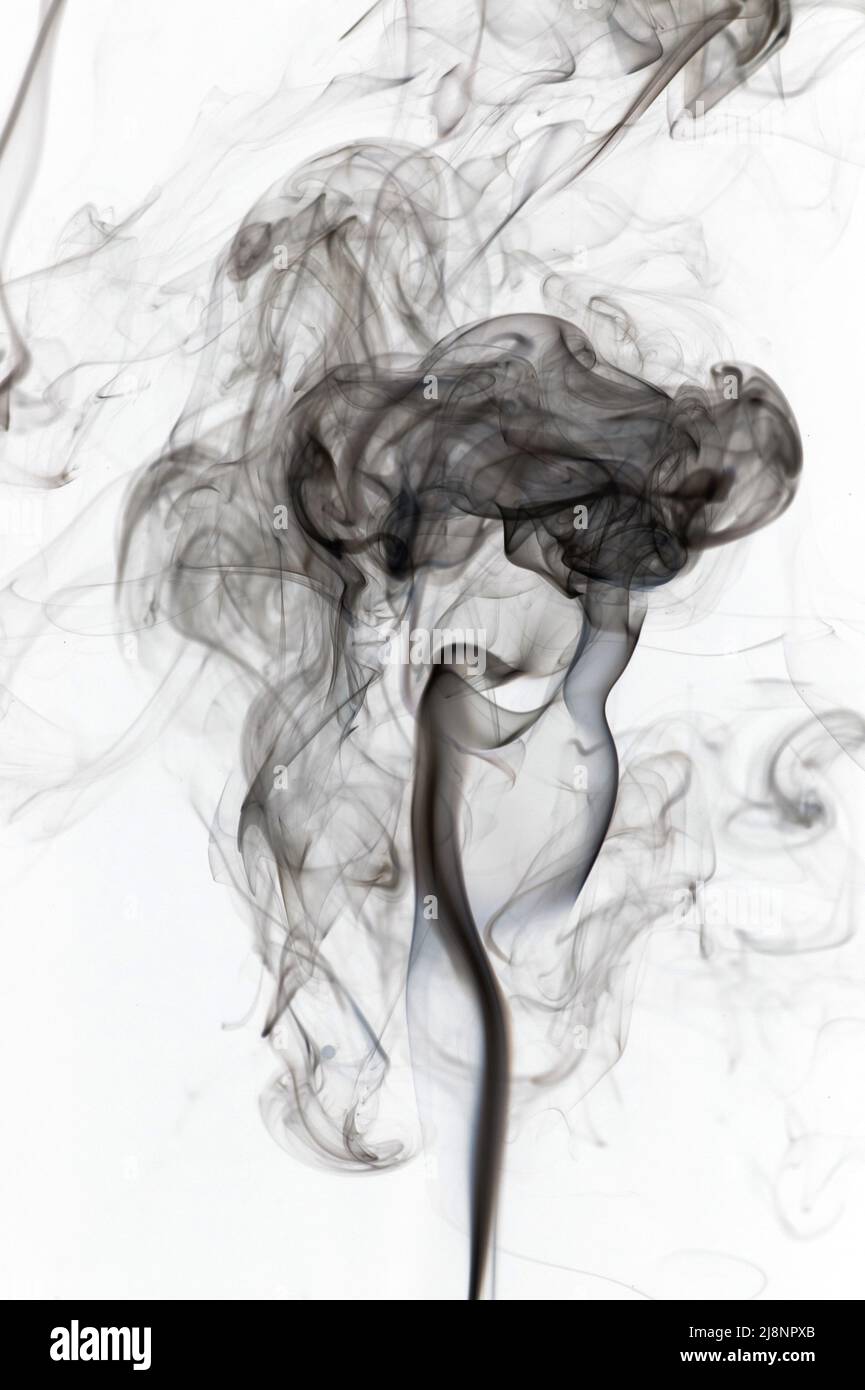 Puffs and curls of dark smoke on a white background rising from a ...