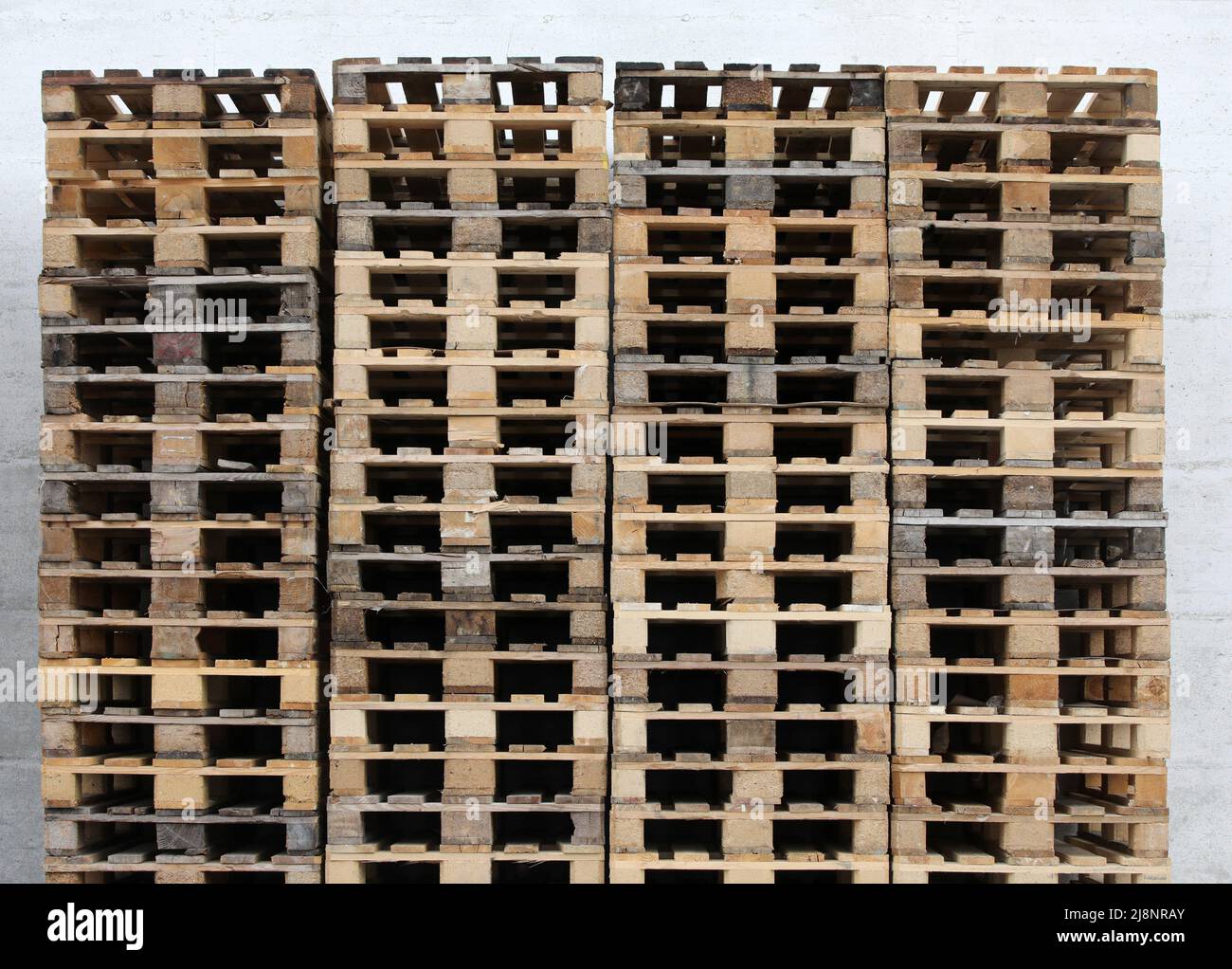 large pile of wooden pallets piled up in the empty warehouse of a ...