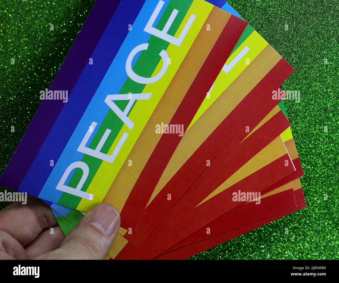 hand holding the peace flag like a playing card to play the winning ...