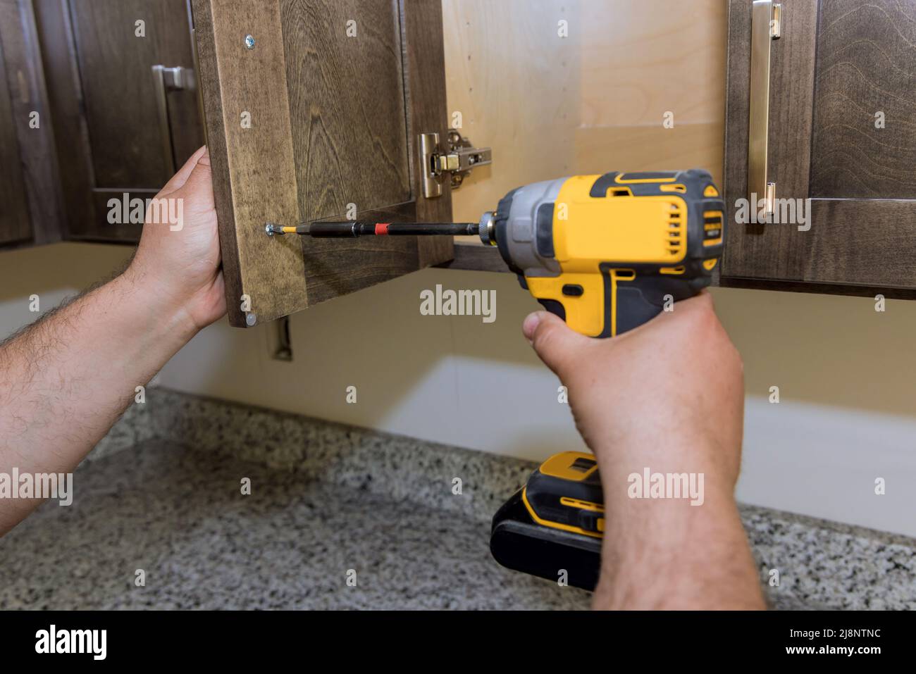Worker hands fixing a hinge to a kitchen cabinet Stock Photo - Alamy