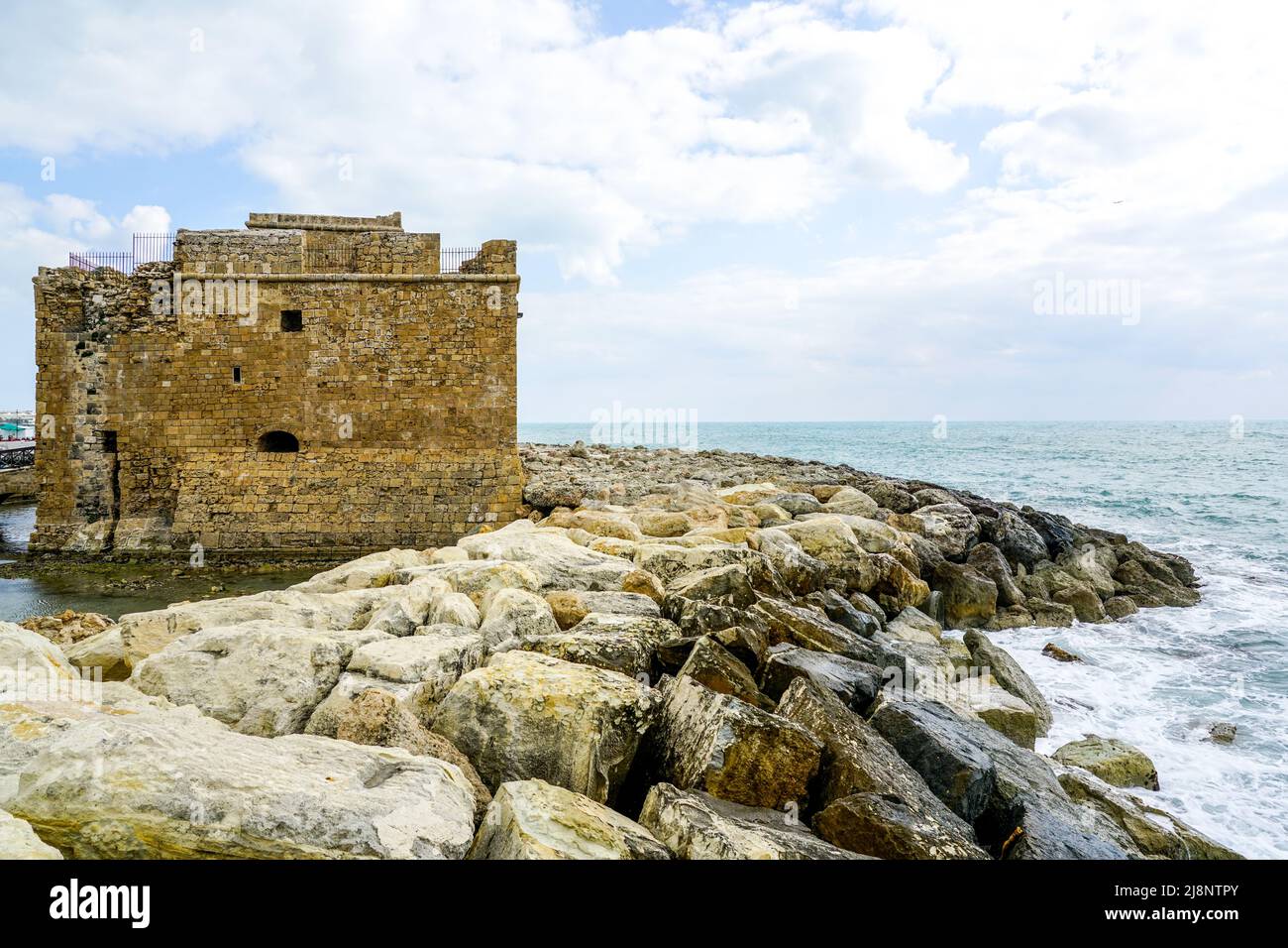 Ancient Paphos Castle in Cyprus and a pier made of large stones against ...