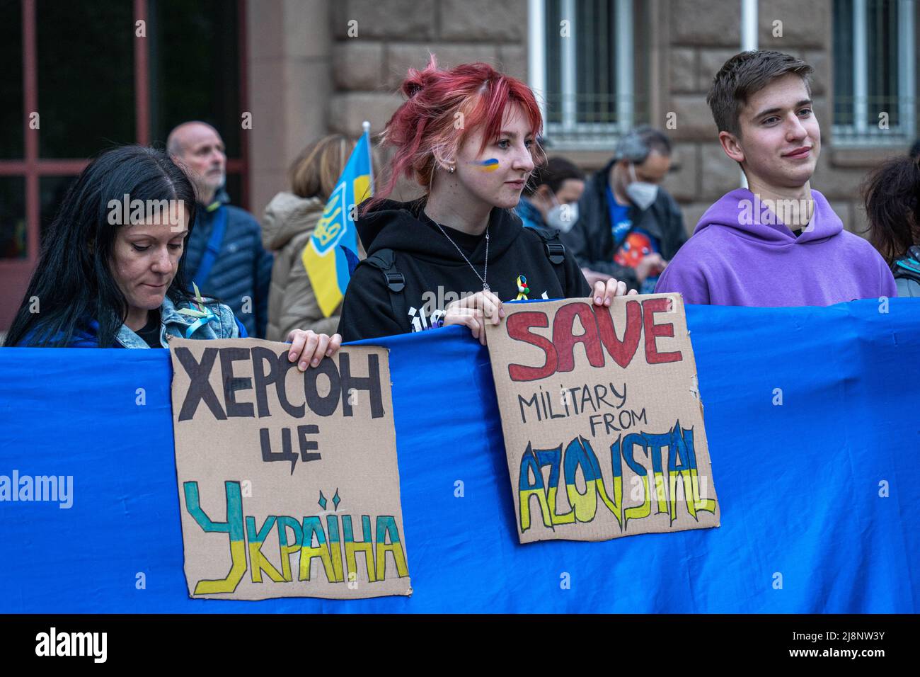 Sofia, Bulgaria - April 28, 2022 - Three persons stand in a row ...