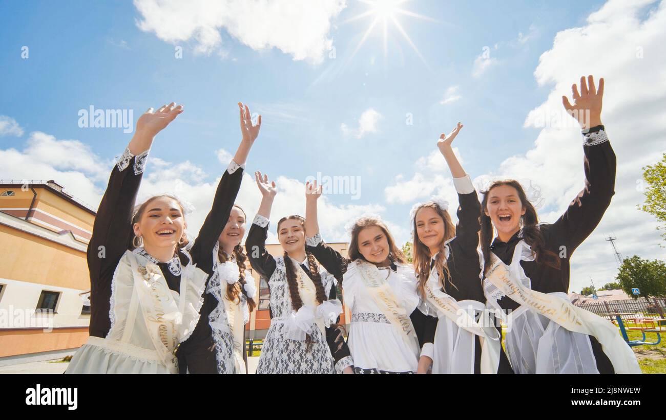 Happy Russian school graduates are stretching their hands on their last ...
