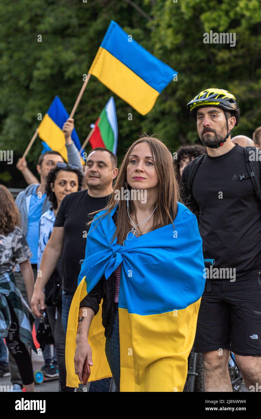 A female with a decisive look, wrapped in Ukrainian flag, walks in a ...