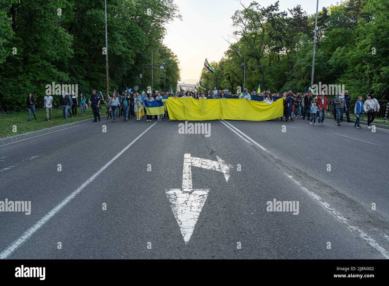 A crowd walks with a giant flag of Ukraine at the Support Ukraine ...