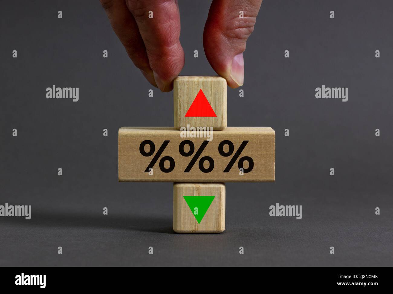 Interest rates symbol. Businessman holds wooden cubes with an arrow ...
