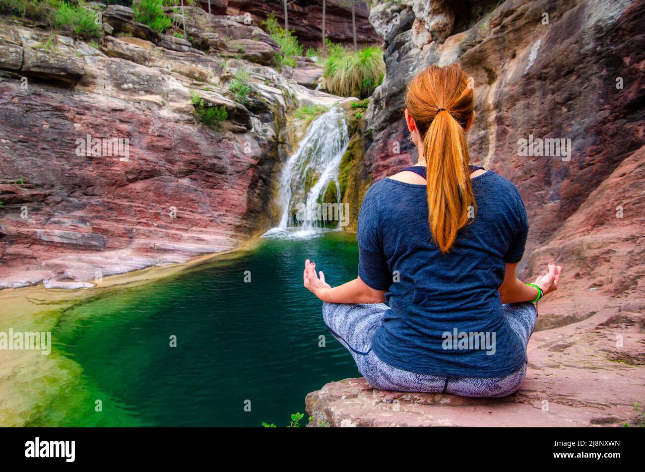 Girl meditating in a beautiful waterfall Stock Photo - Alamy