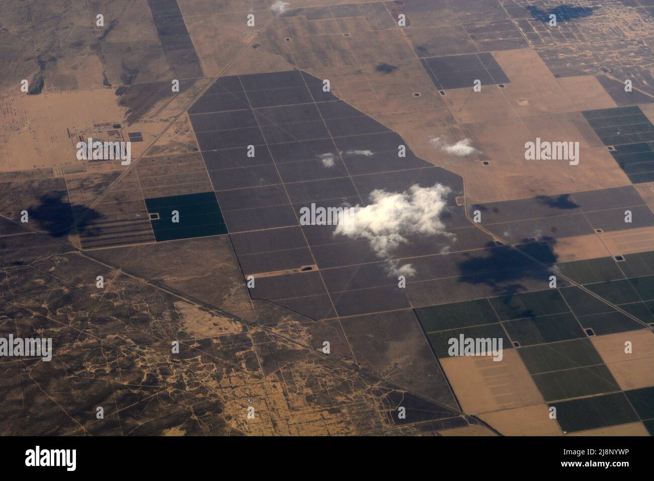 A view of clouds and irrigated fields as seen from a passenger aircraft ...