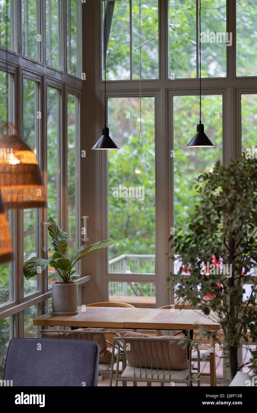 Cozy interior of restaurant with design wooden table large windows ...
