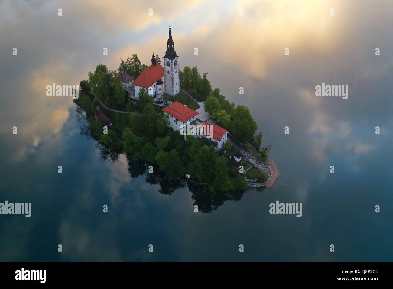 Lake Bled on a beautiful spring morning with mist and low clouds at ...