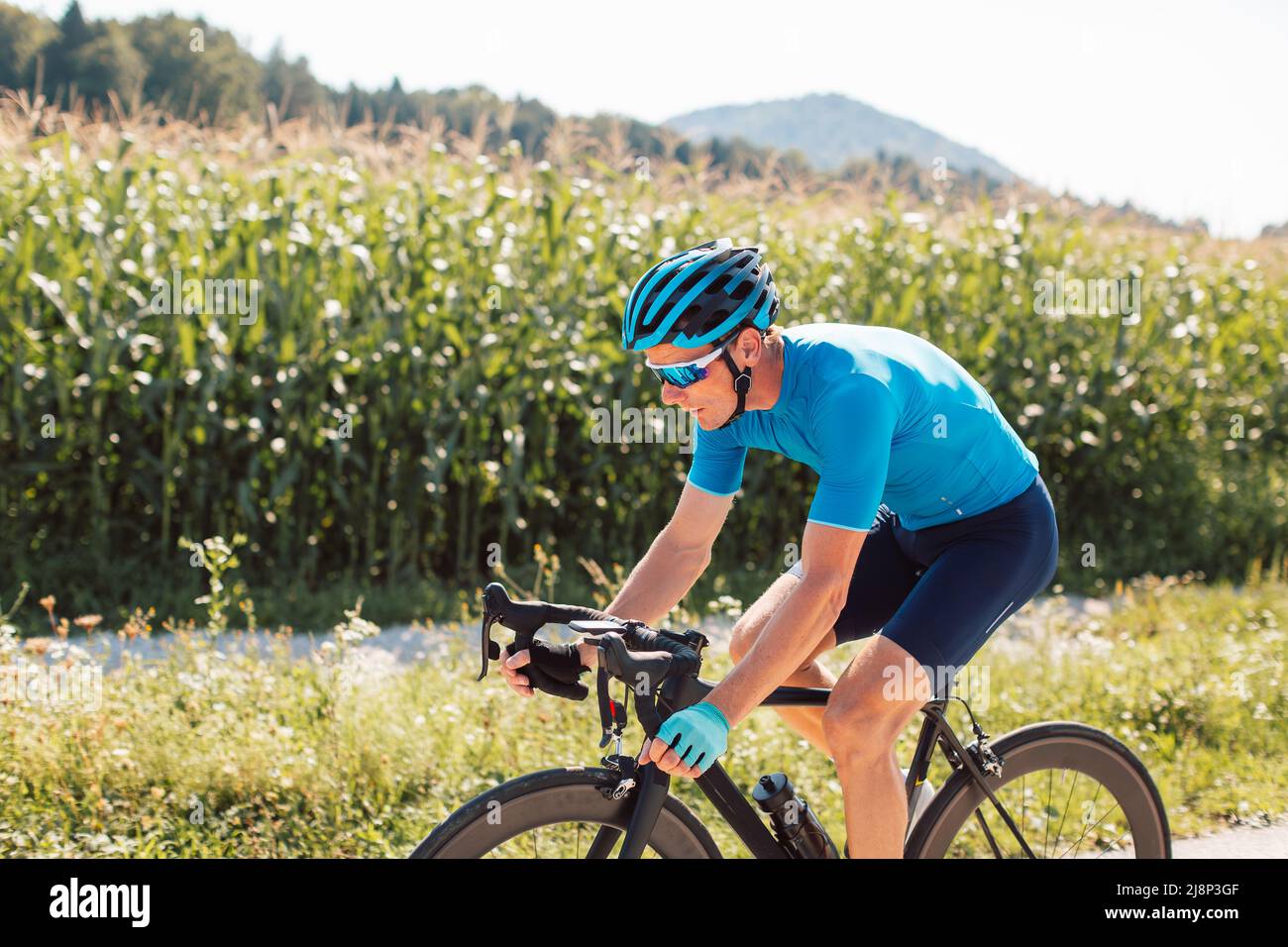 Side view of a male Caucasian road cyclist, in blue sportswear with ...