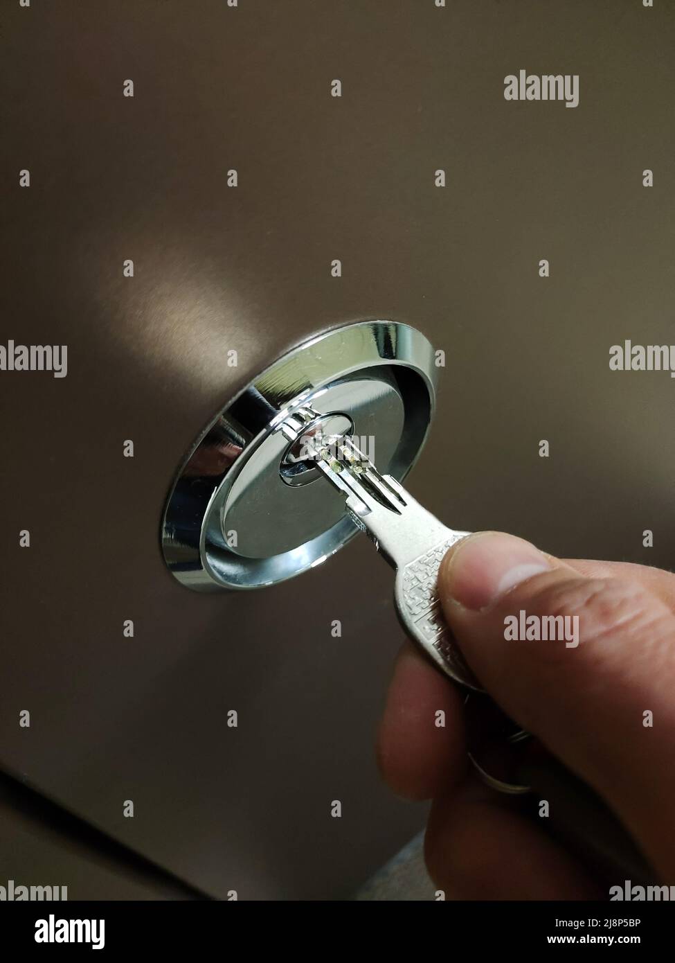A hand opens a lock in an iron door with a key. Top view, close up ...