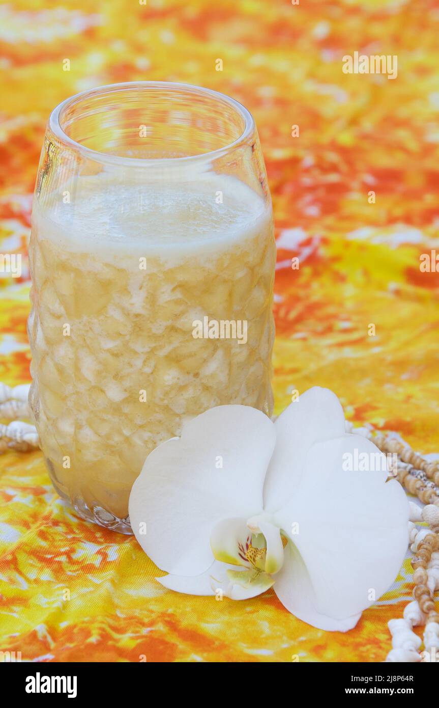 Ice-cold Piña Colada in a tall glass on festive orange and yellow ...