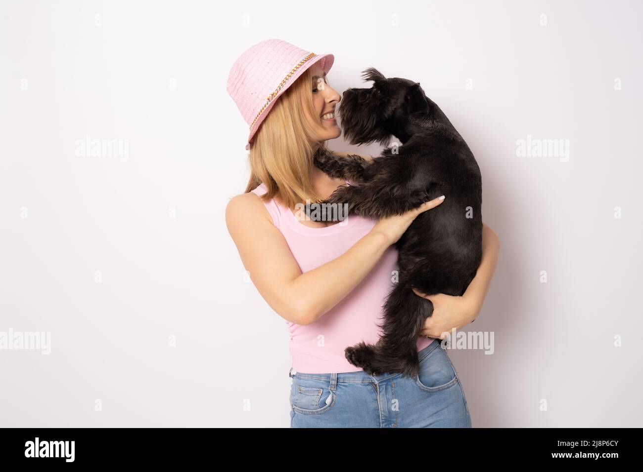 Cute young woman hugs her puppy schnauzer dog. Love between owner and ...