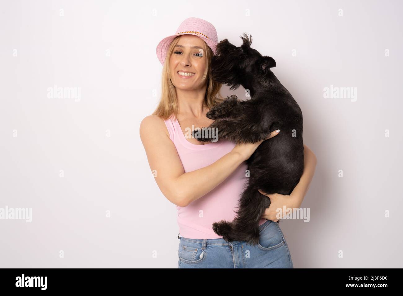 Cute young woman hugs her puppy schnauzer dog. Love between owner and ...