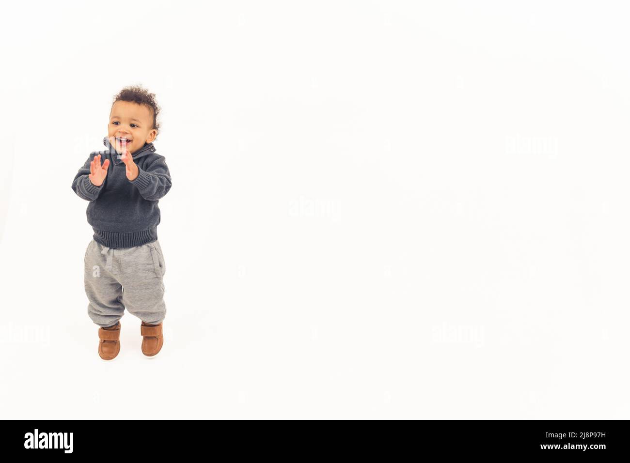 Adorable multiracial baby having fun, clapping his hands and laughing ...