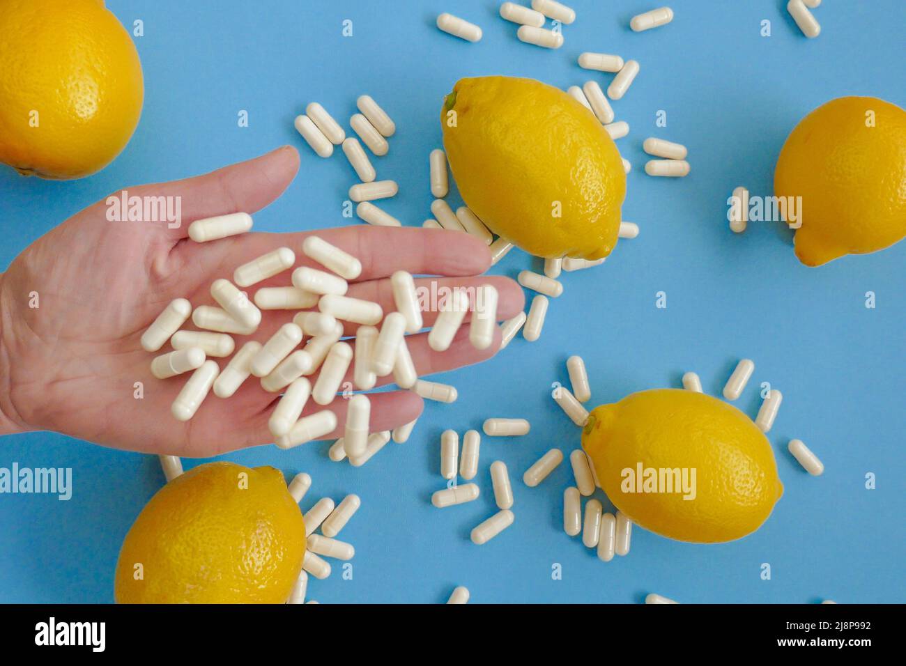 Vitamin C tablets. White capsules of vitamin C in a hand and yellow ...