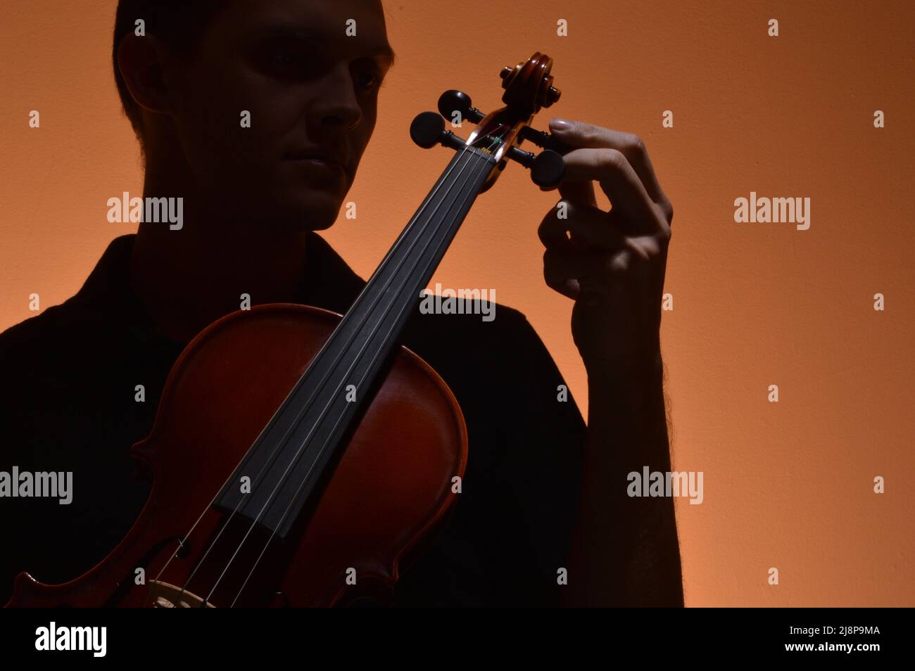 Violin being tuned by musician Stock Photo - Alamy