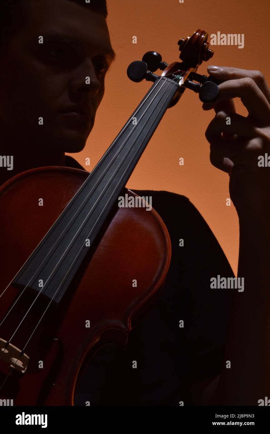 Violin being tuned by musician Stock Photo - Alamy