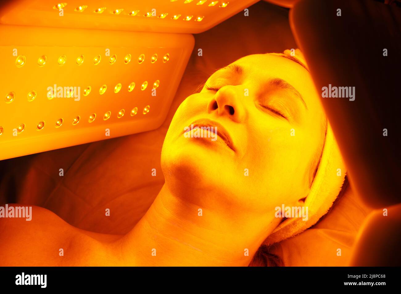 An elderly woman undergoes a facial rejuvenation procedure. Woman face ...