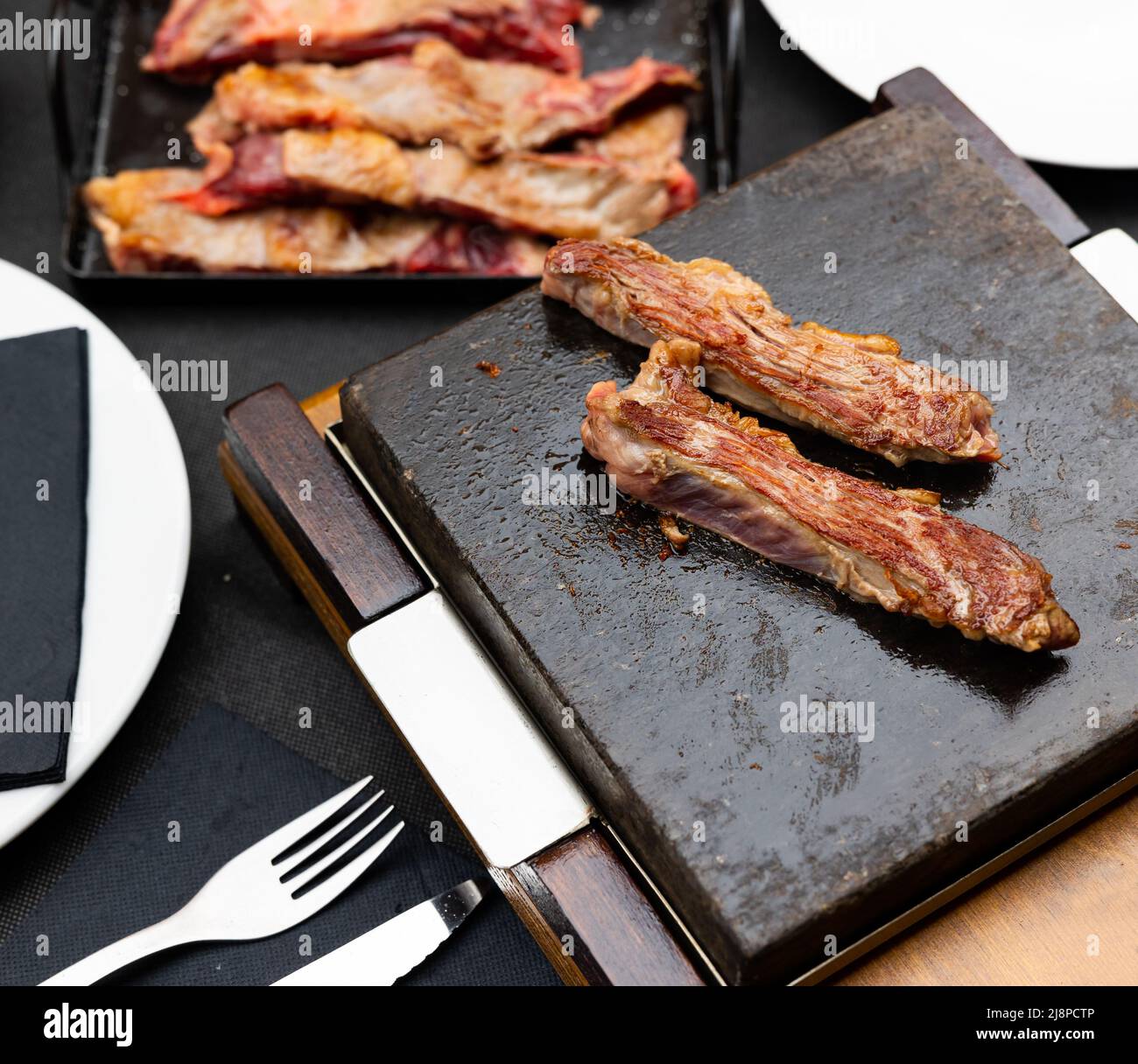 Roasting of fresh beef meat on hot stone Stock Photo - Alamy
