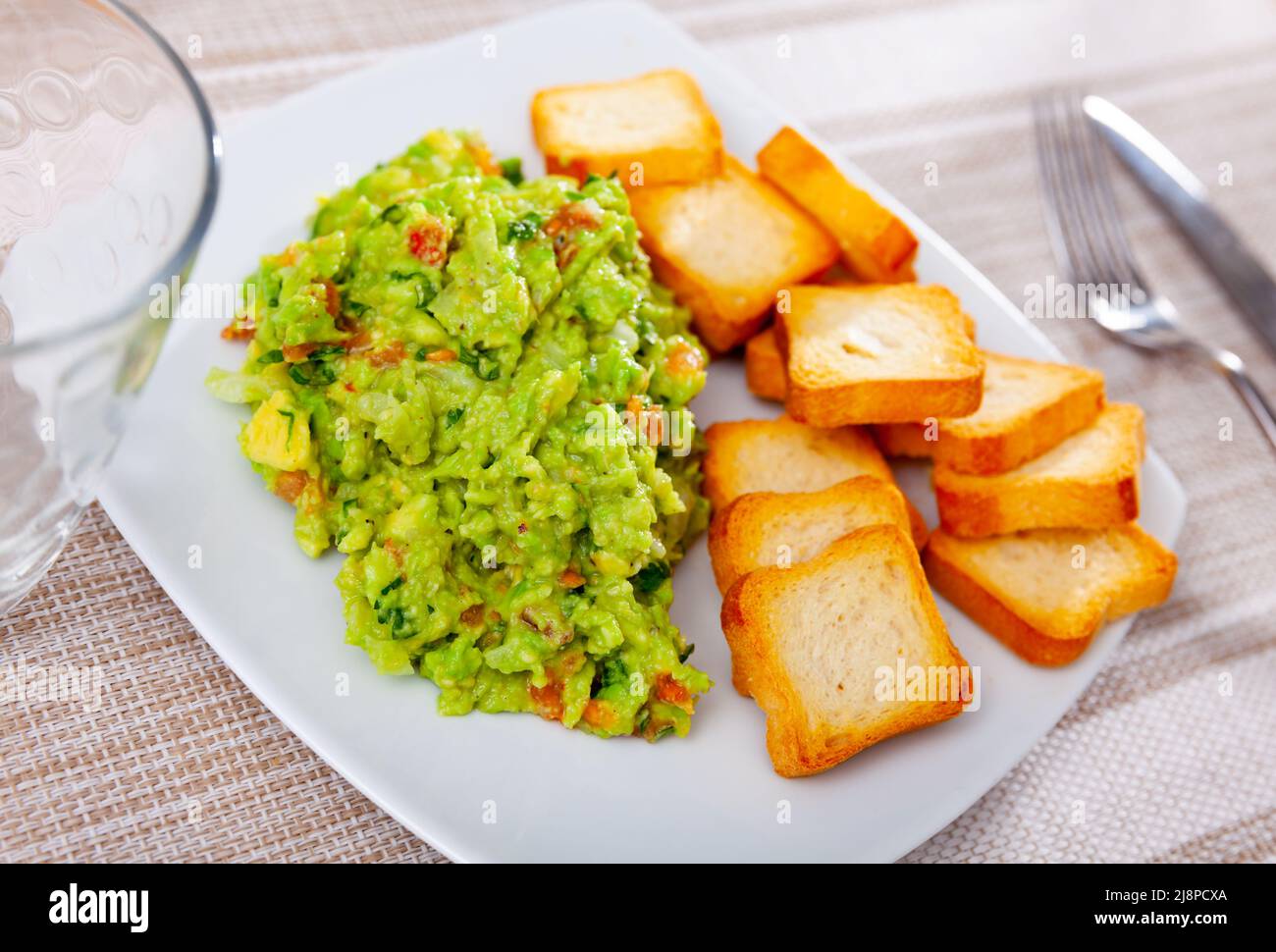 Guacamole dip served with toasted bread Stock Photo - Alamy