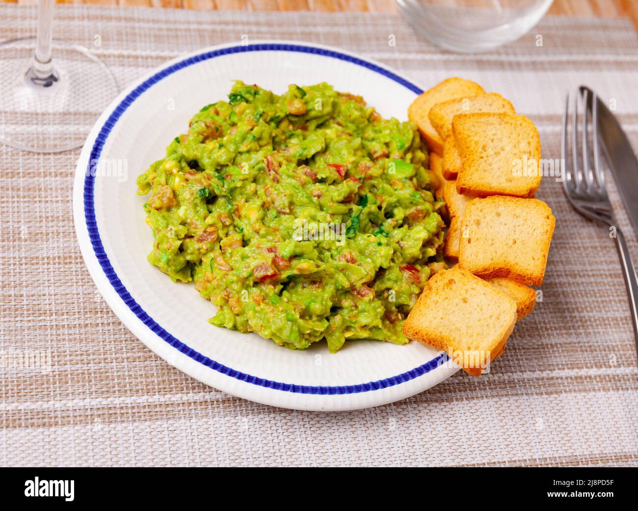 Guacamole dip served with toasted bread Stock Photo - Alamy
