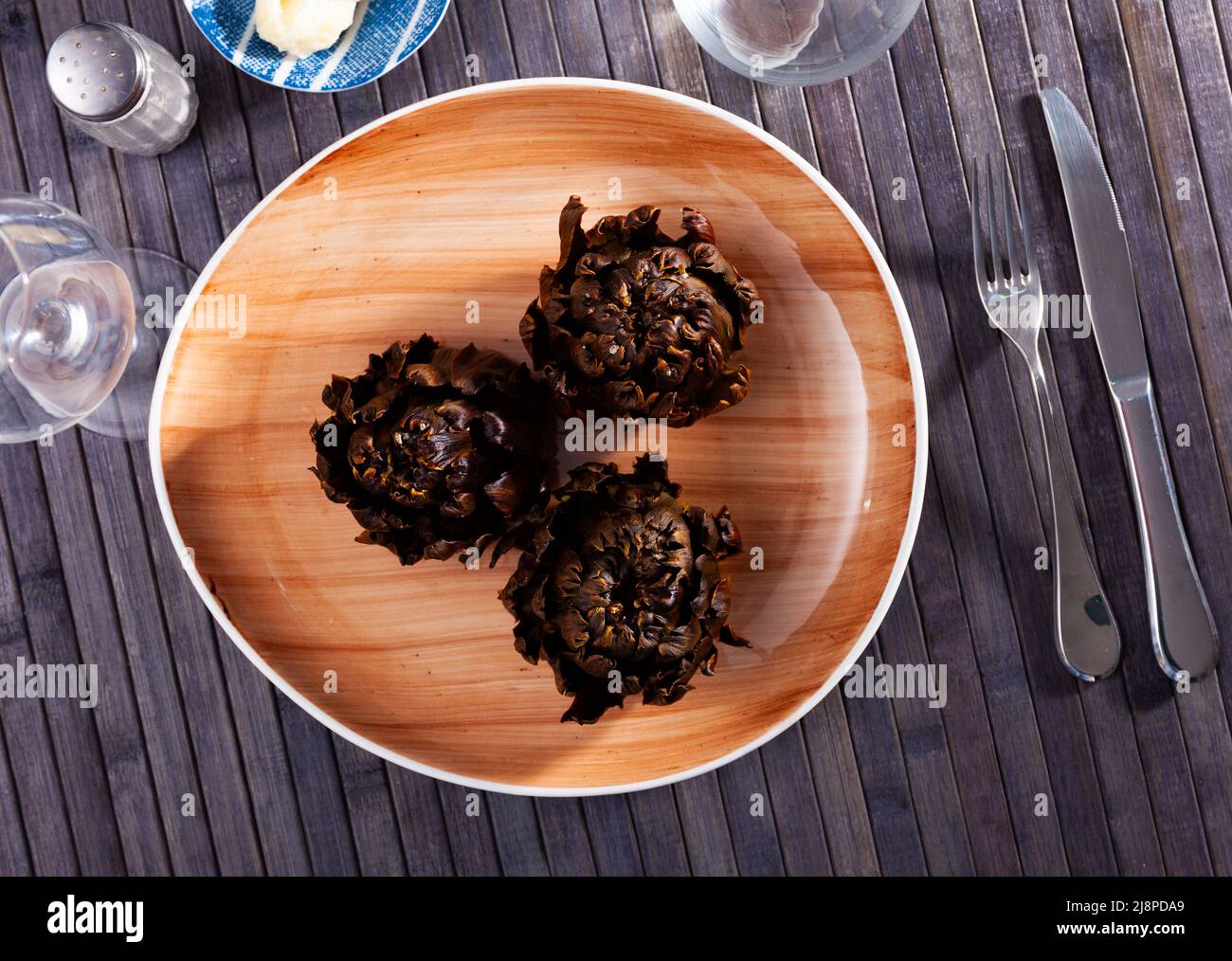 Whole fried crispy delicious artichokes served on plate Stock Photo - Alamy