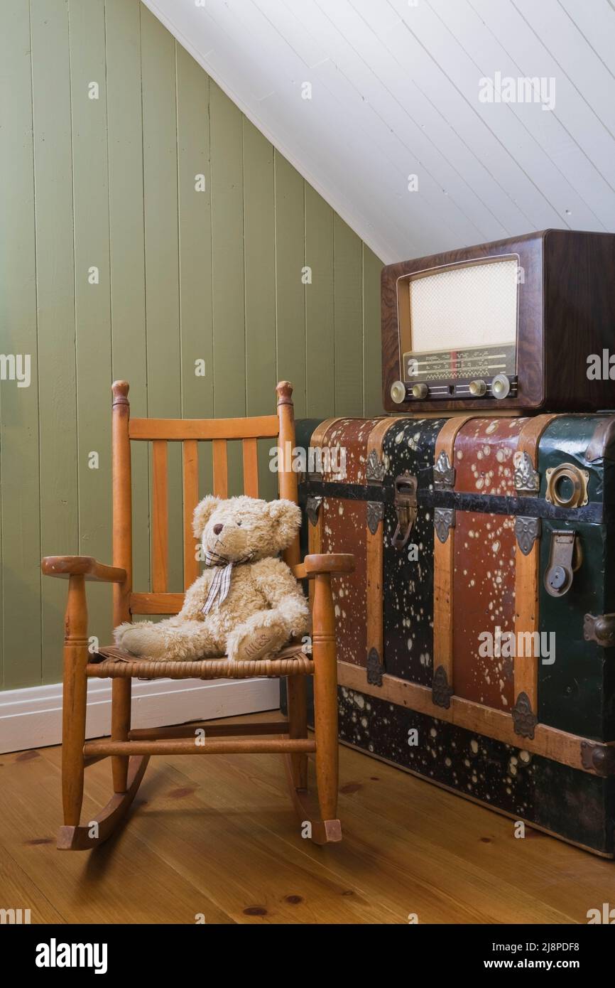 Antique rocking chair with plush teddy bear and radio on top of storage ...