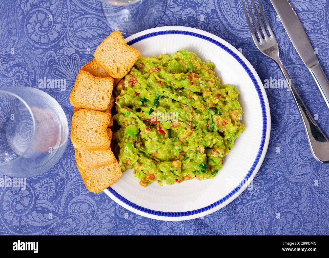 Traditional Mexican guacamole served with crispy toasts Stock Photo - Alamy