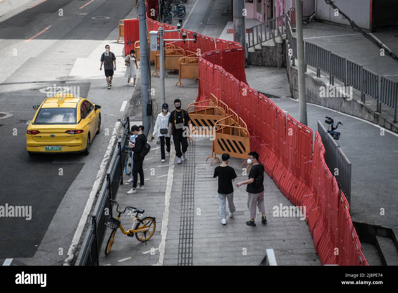 GUANGZHOU, CHINA - MAY 17, 2022 - Citizens walk past a gated community ...